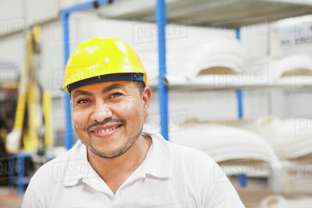 Worker smiling in manufacturing plant - Royalty-free Stock Photo | Dissolve