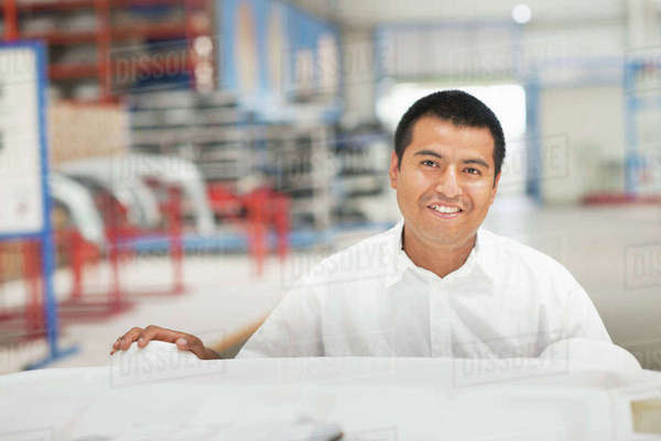 Worker smiling in manufacturing plant - Royalty-free Stock Photo | Dissolve