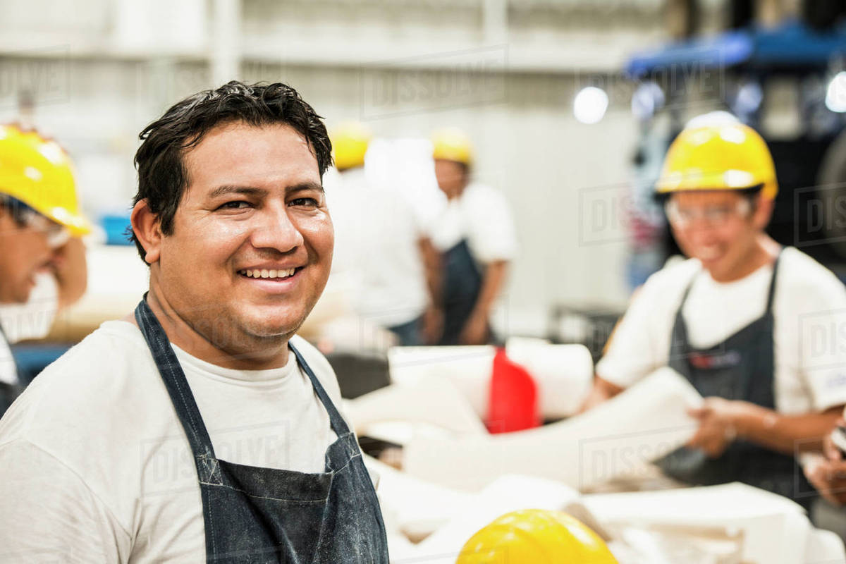 Worker smiling in manufacturing plant - Stock Photo - Dissolve