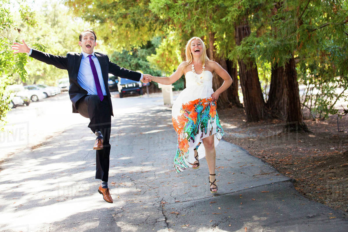 Two People Skipping Holding Hands