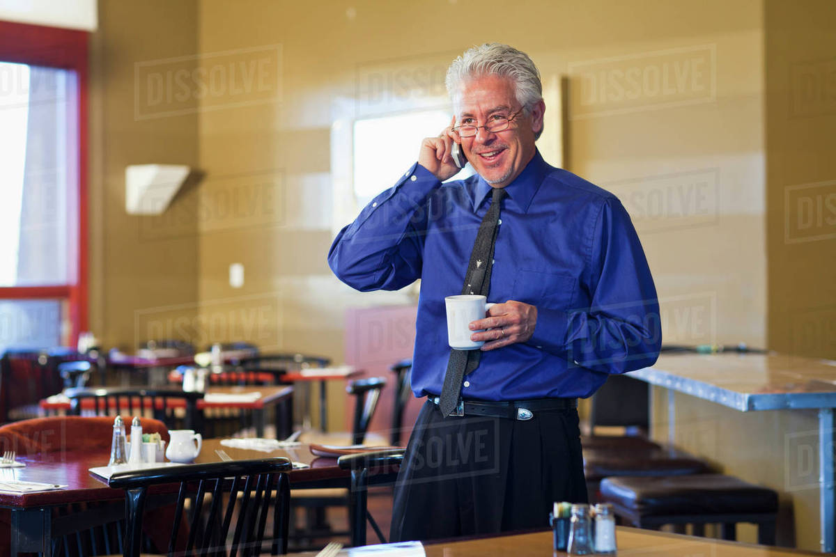 Hispanic cafe owner talking on cell phone - Royalty-free Stock Photo ...