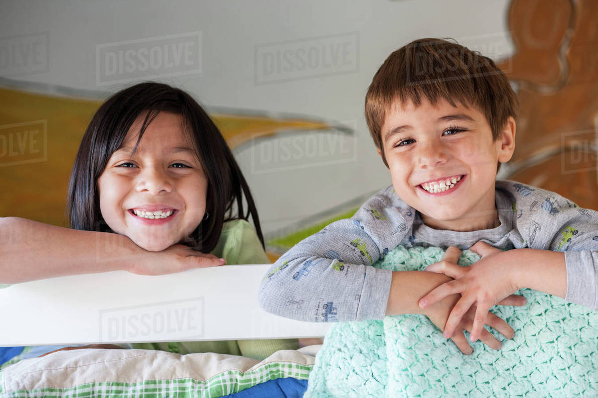Hispanic children smiling in bunk bed - Royalty-free Stock Photo | Dissolve
