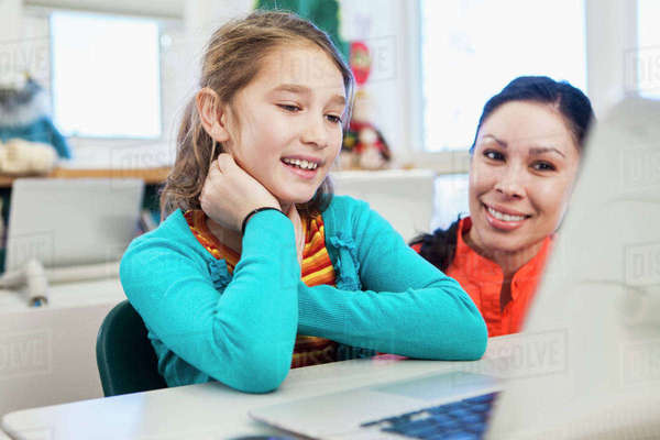 Teacher and student using laptop in library - Royalty-free Stock Photo ...