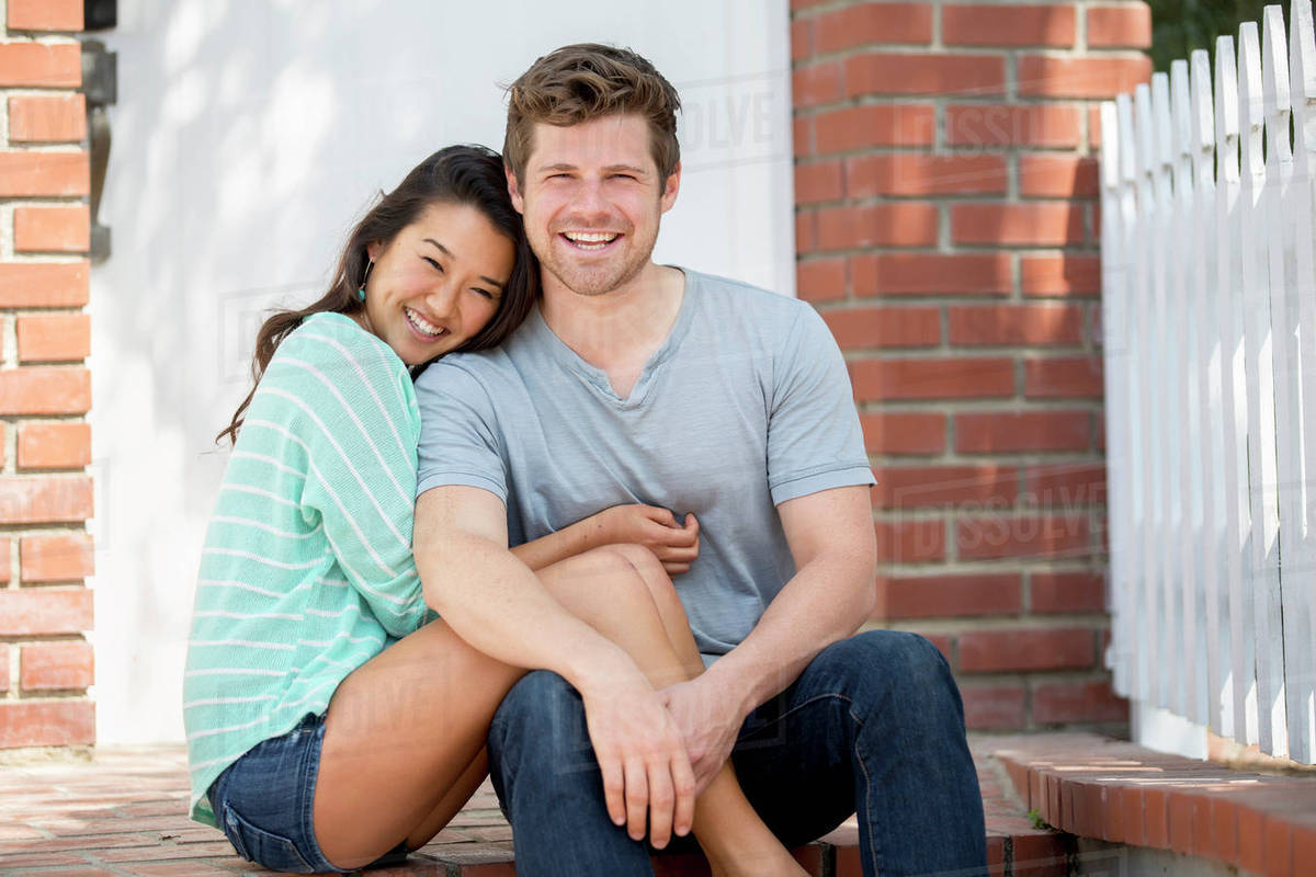 Couple smiling together outdoors - Stock Photo - Dissolve