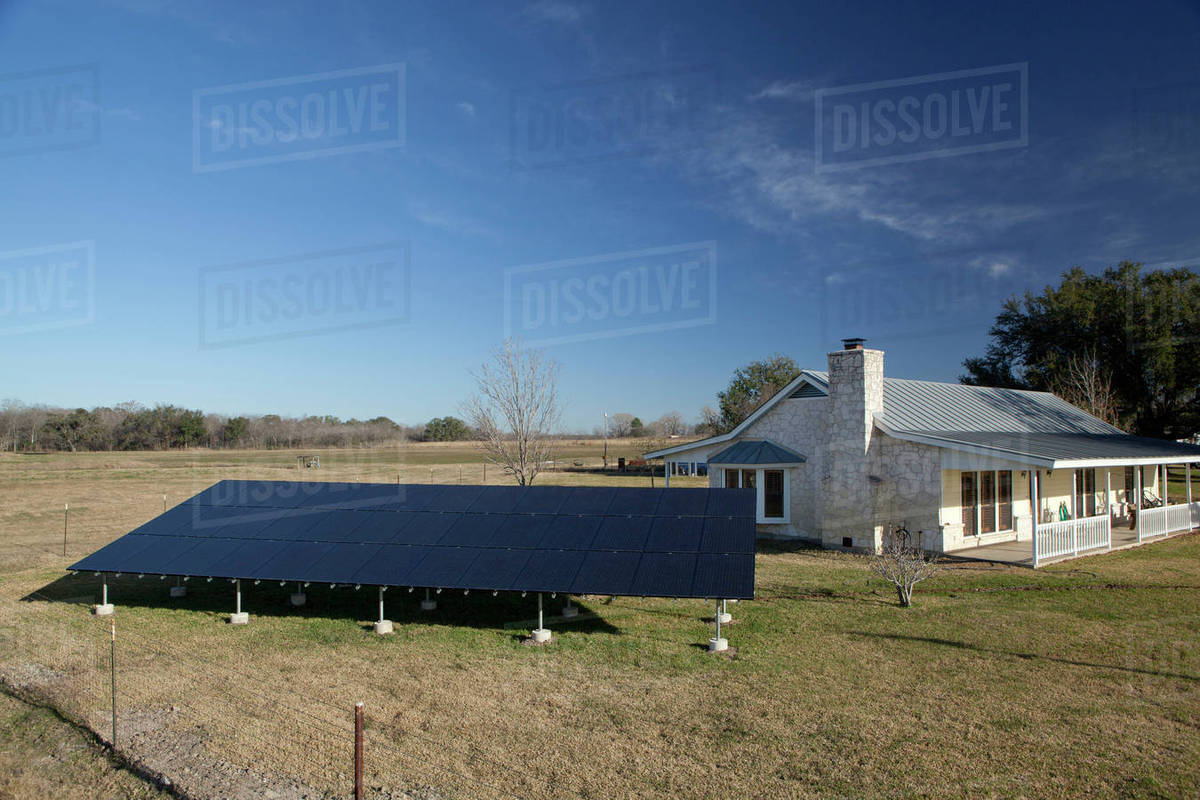 Solar panels outside home in rural landscape - Stock Photo - Dissolve