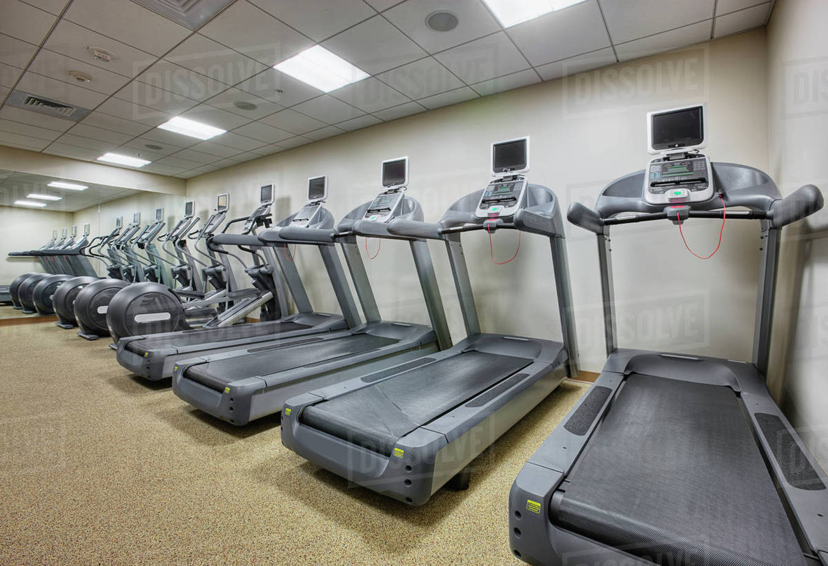Treadmills in a row at gym - Stock Photo - Dissolve