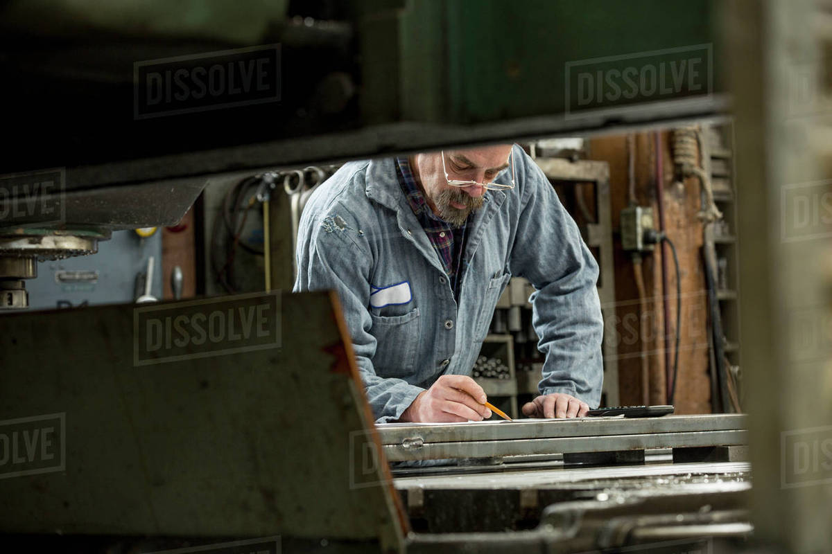 Man working in metal shop - Royalty-free Stock Photo | Dissolve