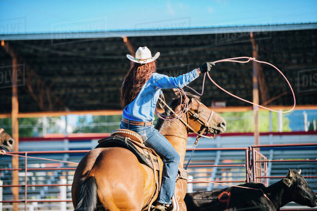 Caucasian cowgirl on horse throwing lasso in rodeo on ranch - Royalty ...
