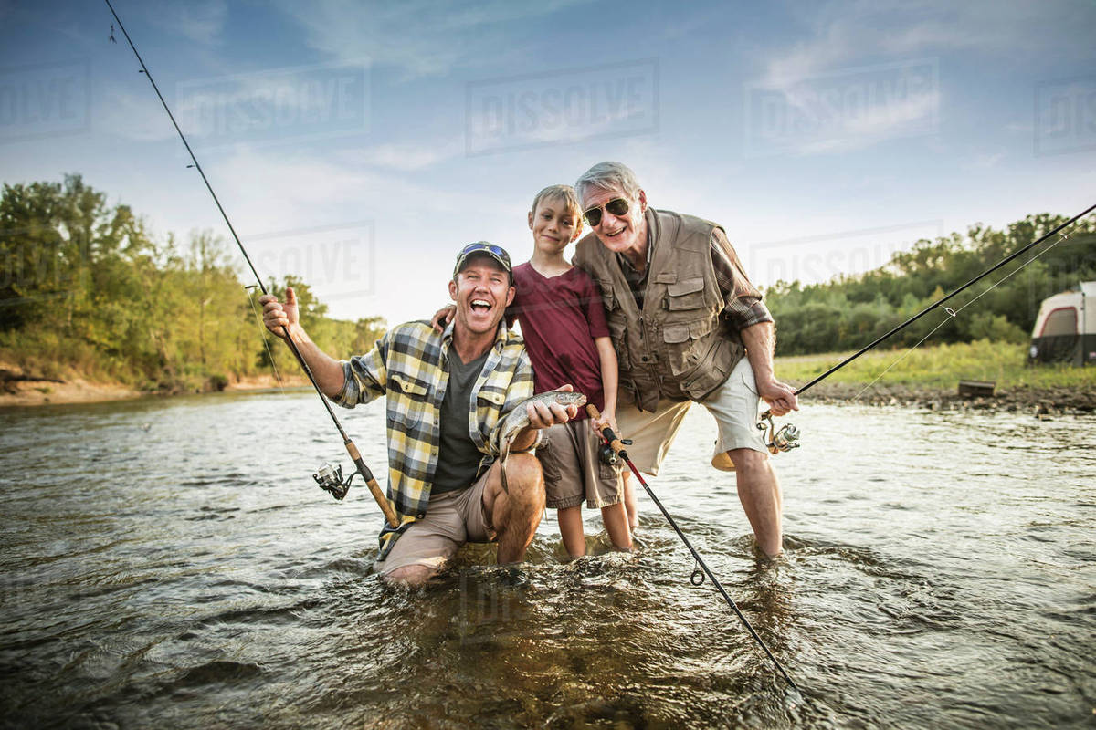 Three generations of Caucasian men fishing in river - Royalty-free ...