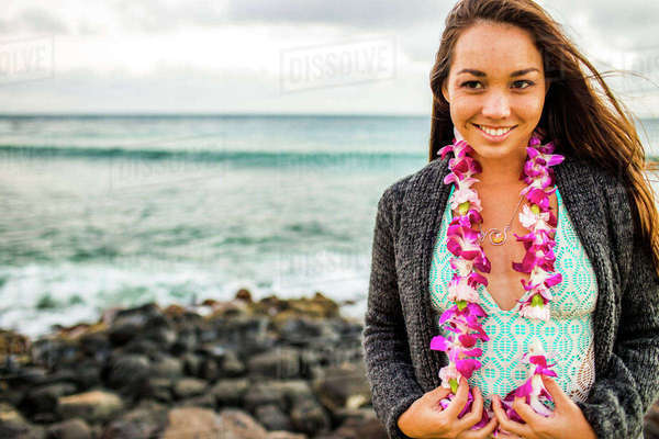 Pacific Islander woman wearing flower lei near rocky beach - Royalty ...