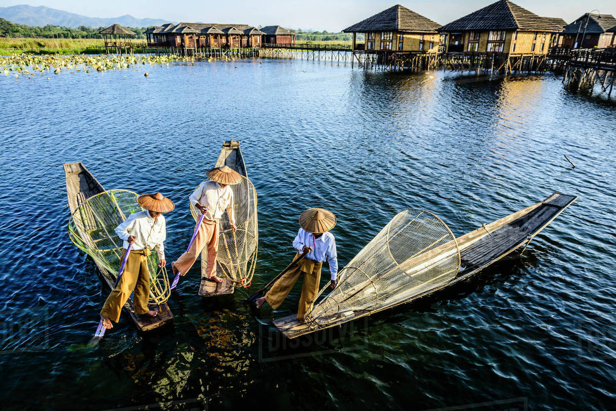 Asian fishermen fishing in canoes on river - Stock Photo - Dissolve