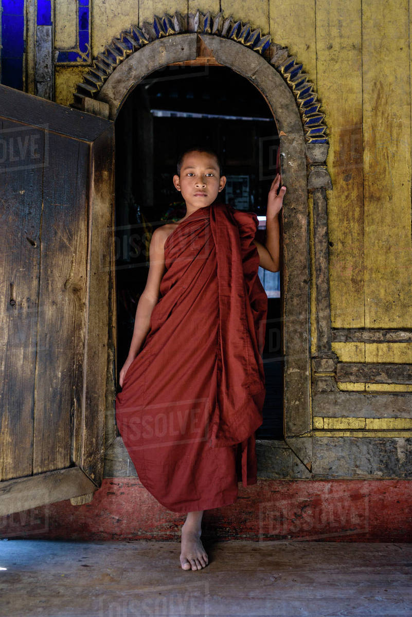 Asian monk-in-training walking out of temple archway - Royalty-free ...