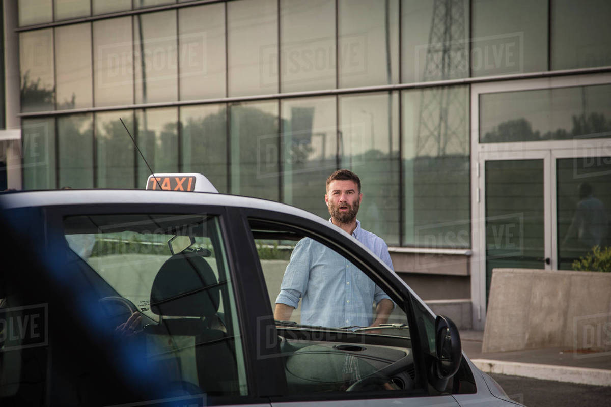 Caucasian man walking towards taxi - Stock Photo - Dissolve