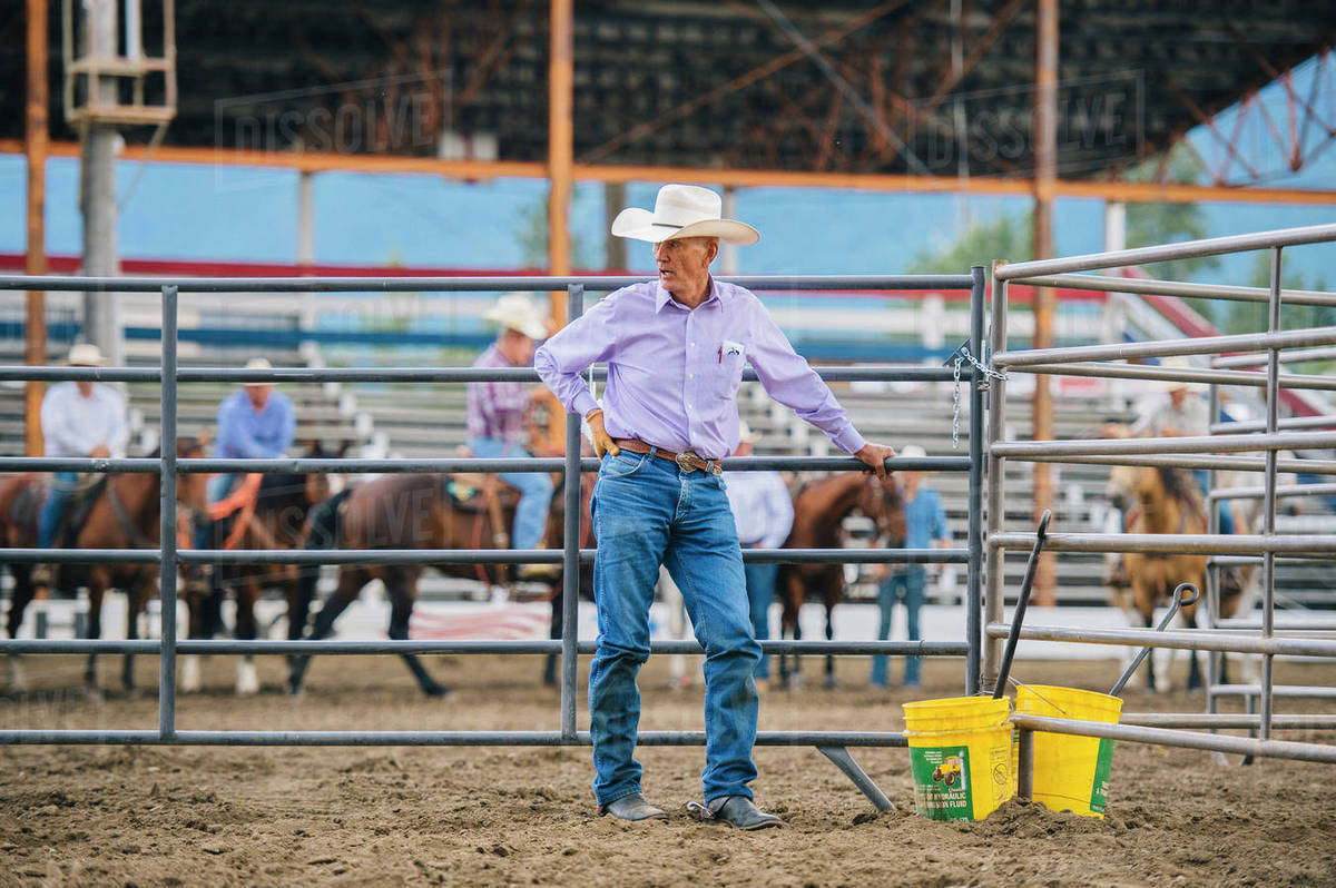 Caucasian cowboy standing at rodeo fence - Royalty-free Stock Photo ...