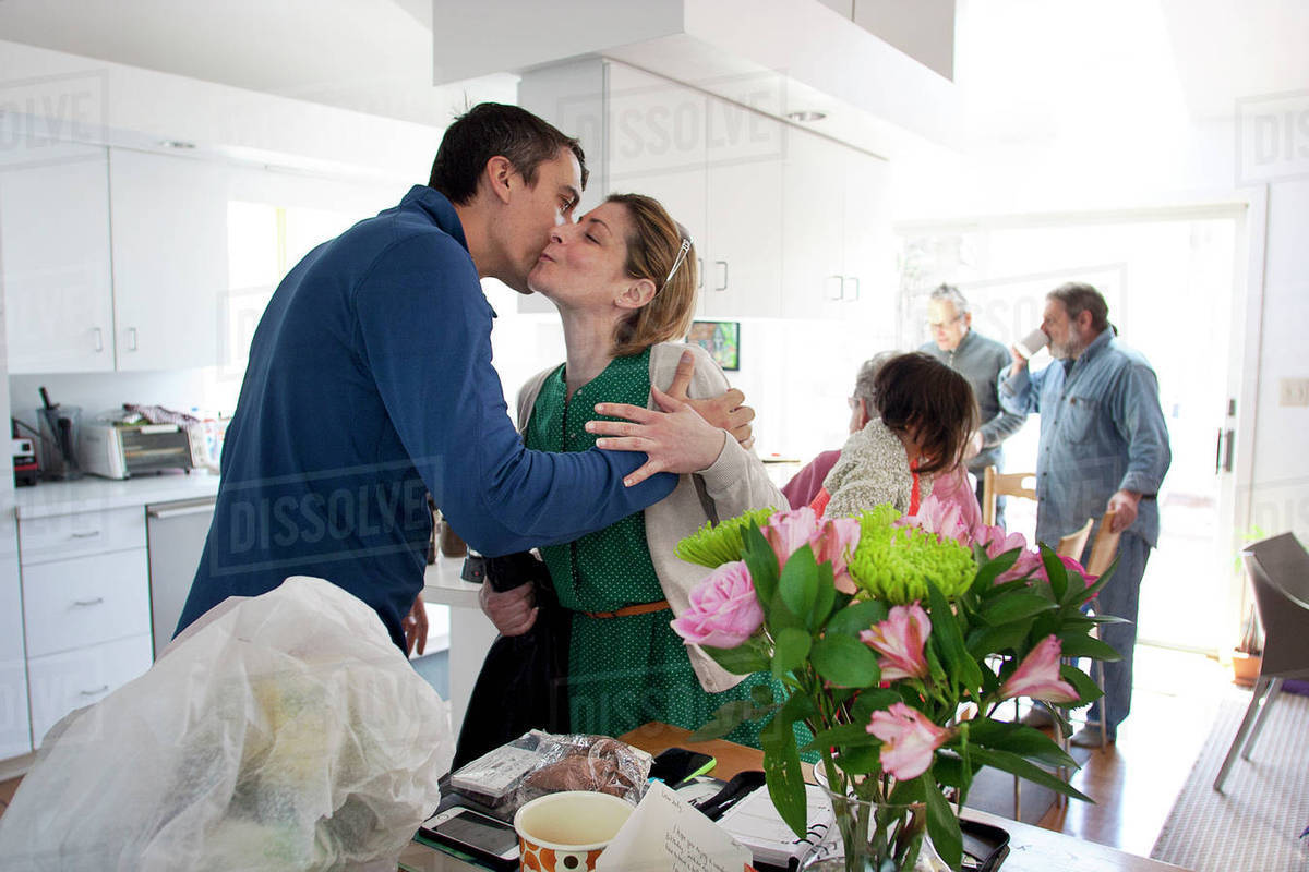 Couple kissing in kitchen - Stock Photo - Dissolve