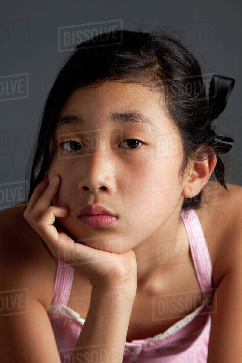 Close up of bored Asian girl - Stock Photo - Dissolve