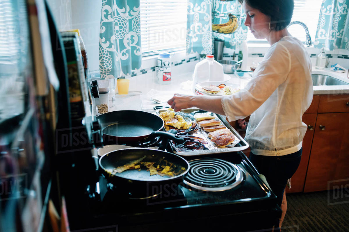 Woman cooking breakfast in kitchen - Stock Photo - Dissolve