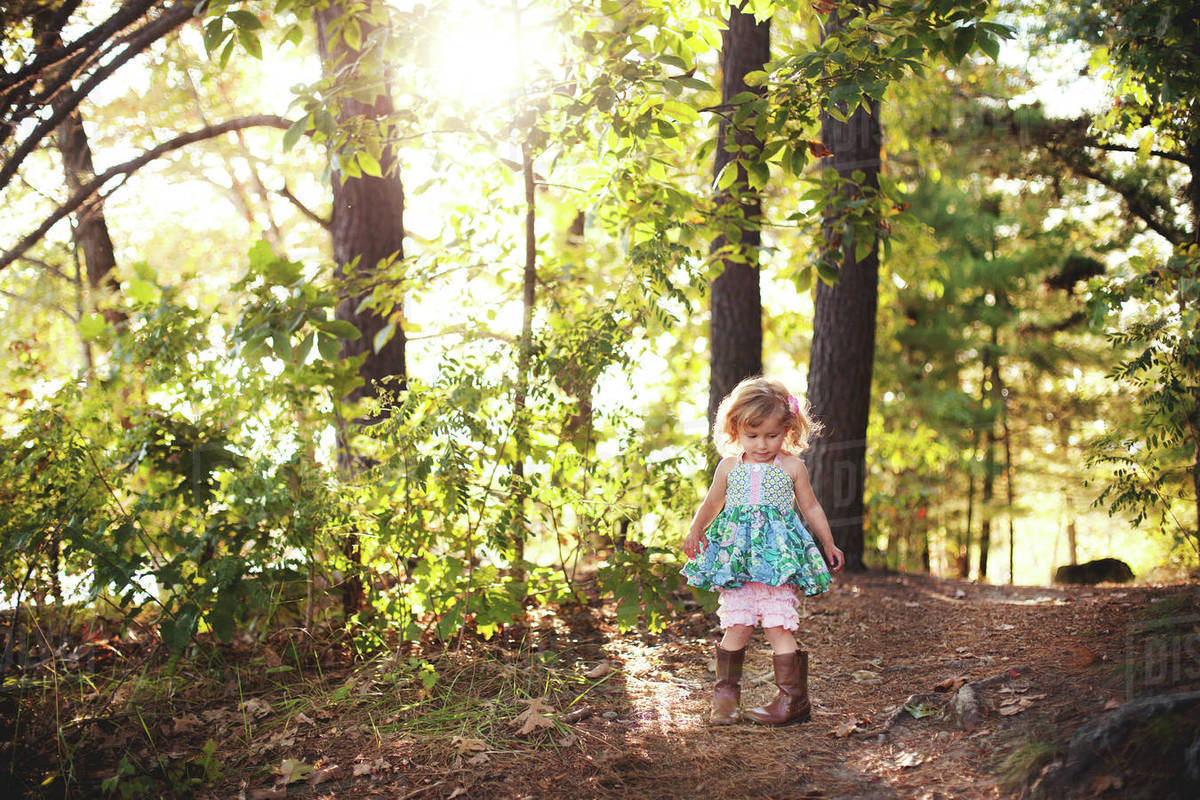 Girl walking on forest path - Stock Photo - Dissolve