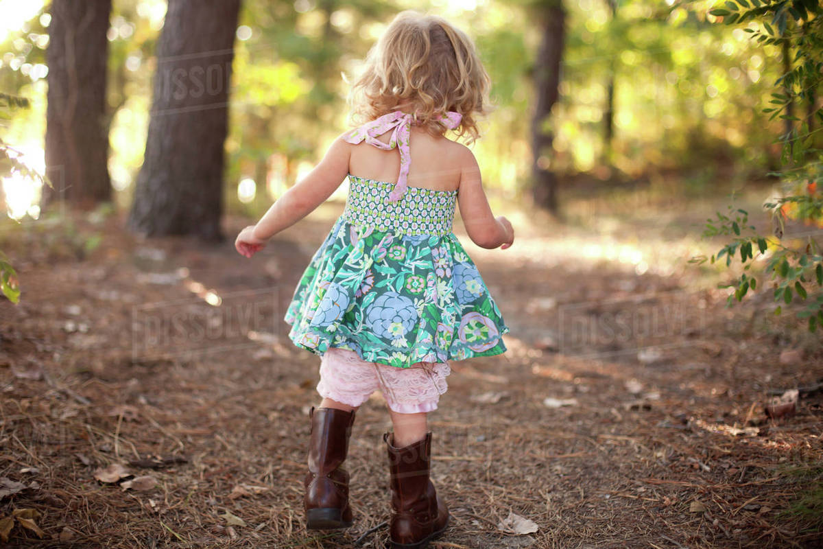 Girl walking on forest path - Stock Photo - Dissolve