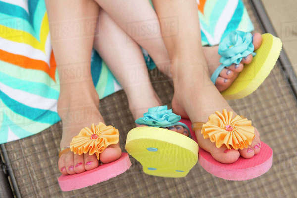 Close up of Caucasian girls wearing flipflops on lawn chair - Stock ...