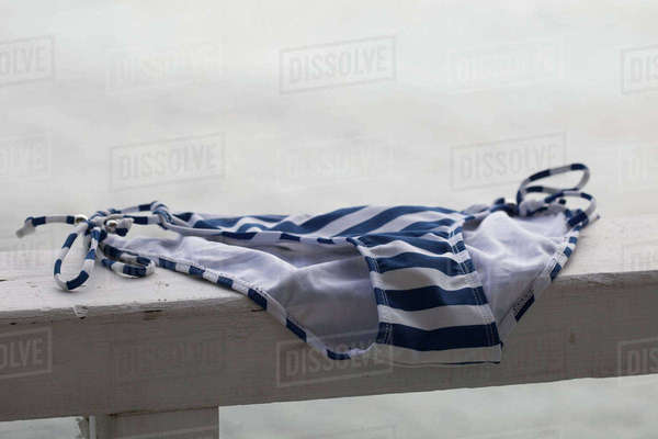Close up of bikini bottoms drying on banister - Stock Photo - Dissolve