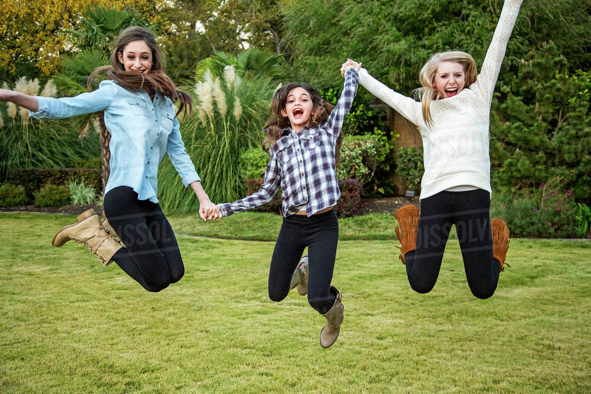 Caucasian teenage girls jumping for joy in backyard - Stock Photo ...