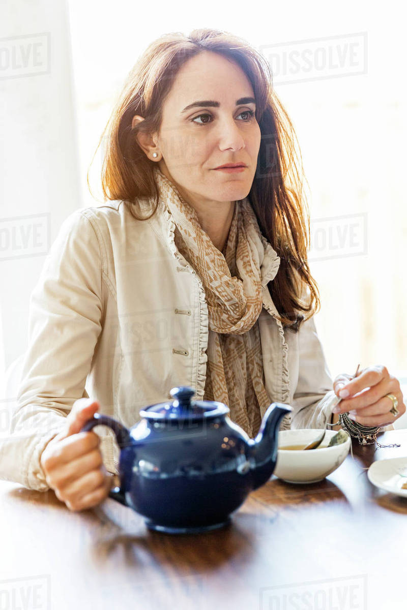 Caucasian woman drinking tea at table - Stock Photo - Dissolve