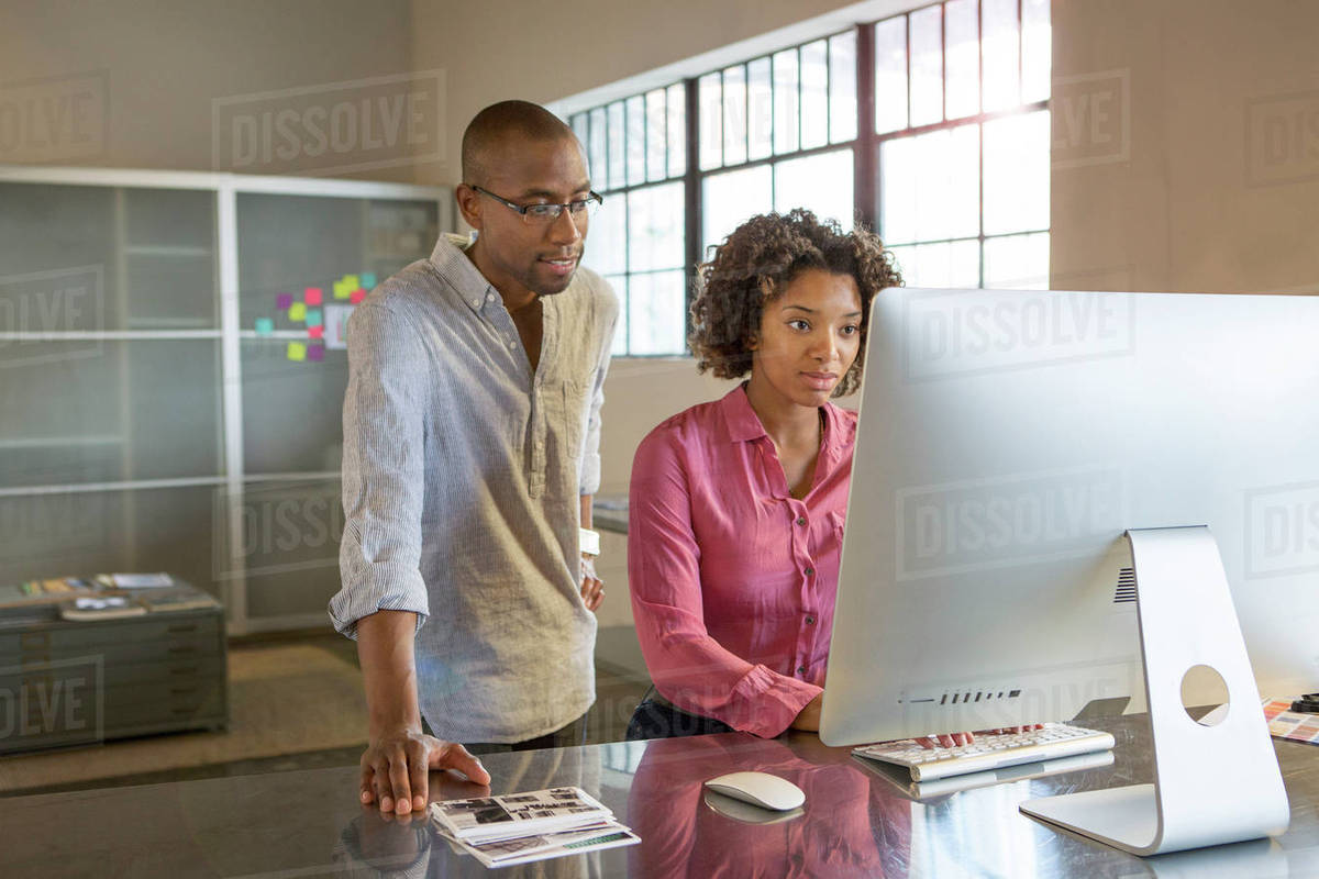 Business people using computer in office - Stock Photo - Dissolve