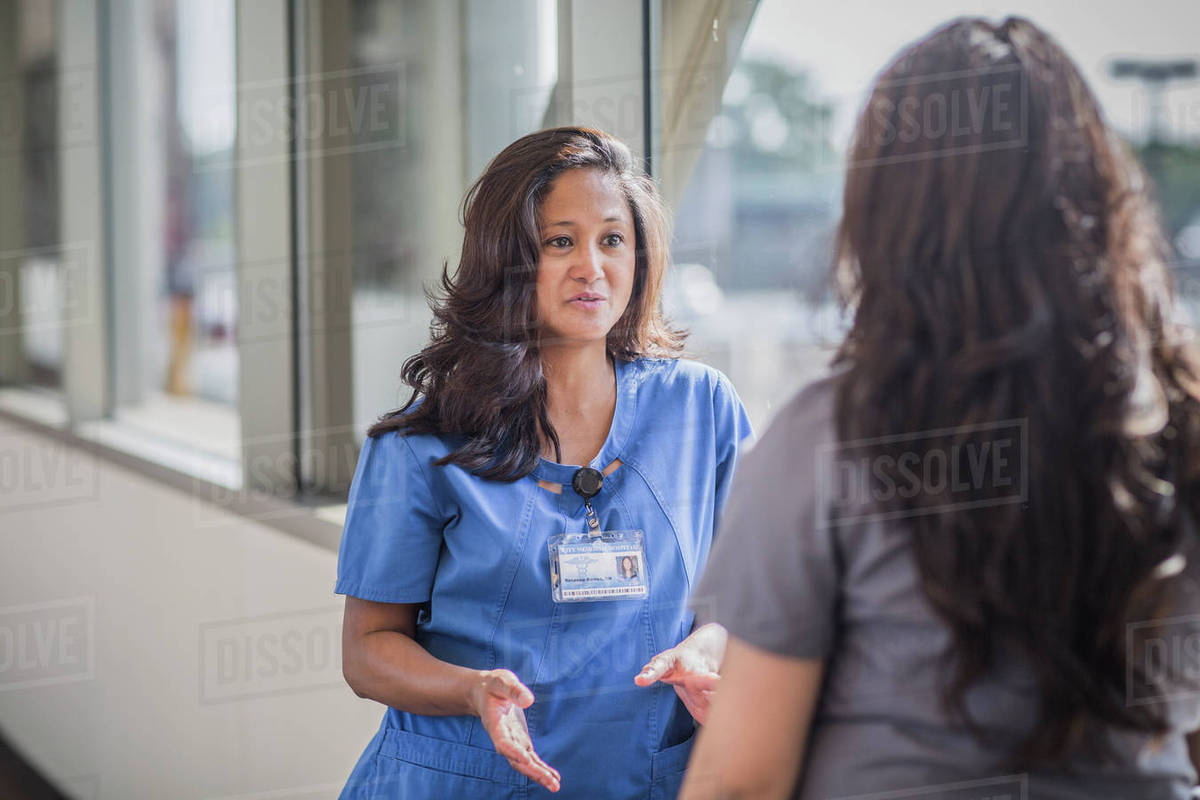 Nurses talking in hospital hallway - Royalty-free Stock Photo | Dissolve