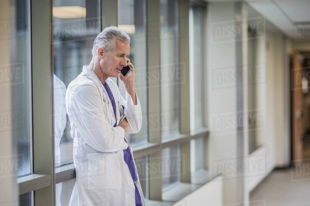 Caucasian doctor talking on cell phone - Royalty-free Stock Photo ...