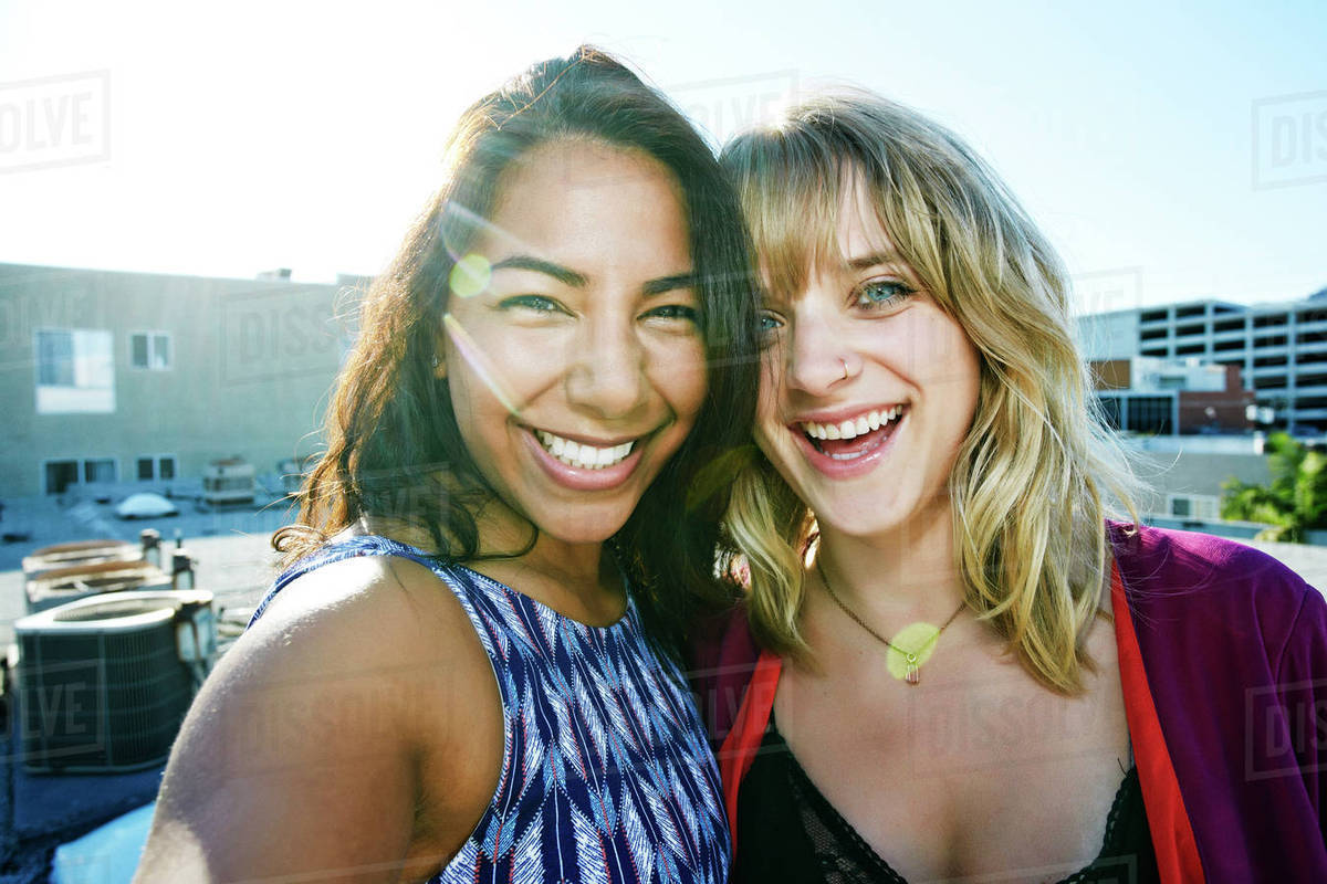 Women hugging on urban rooftop - Royalty-free Stock Photo | Dissolve
