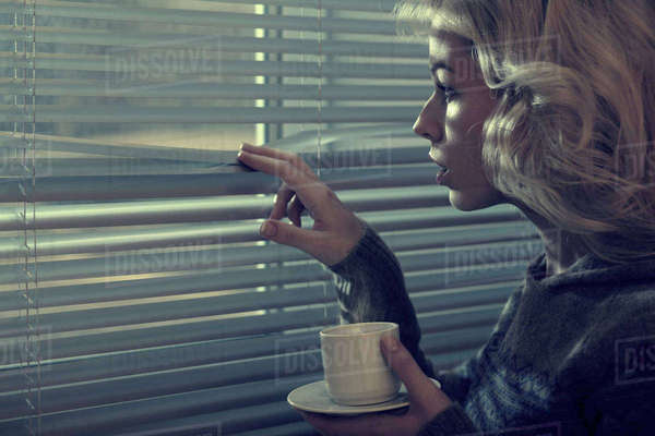 Caucasian woman peering through blinds - Royalty-free Stock Photo ...