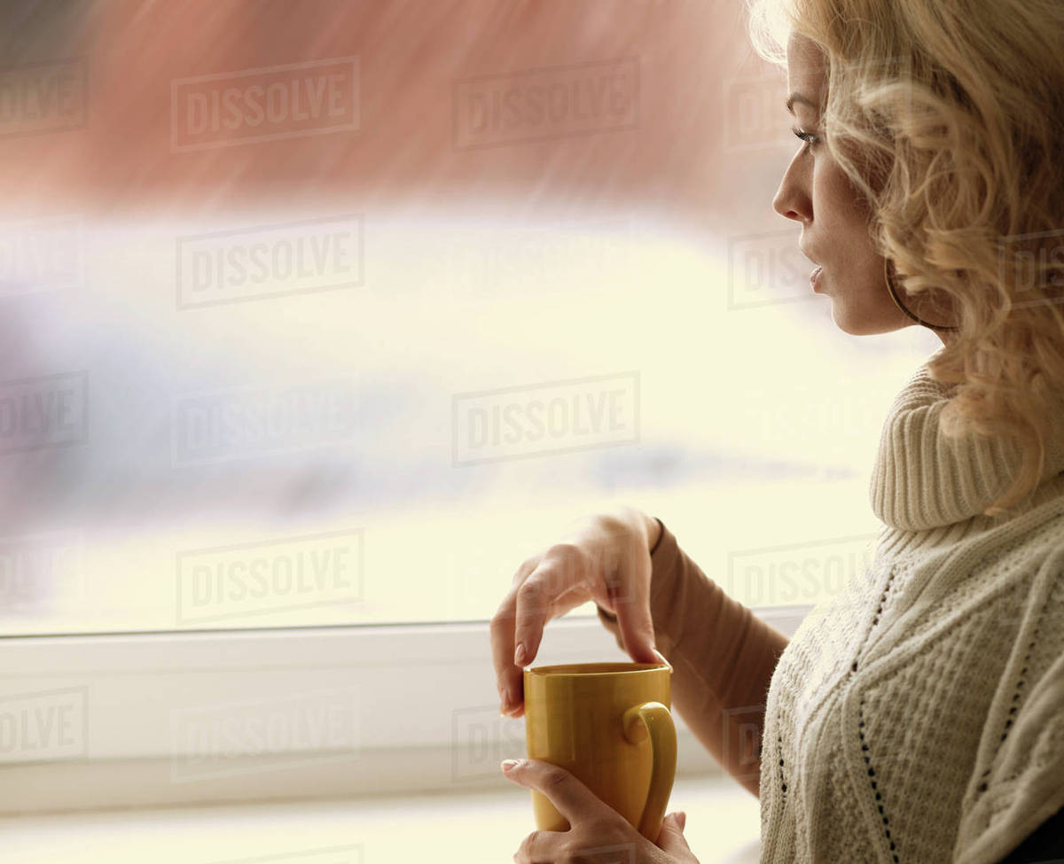 Caucasian woman looking out window - Royalty-free Stock Photo | Dissolve