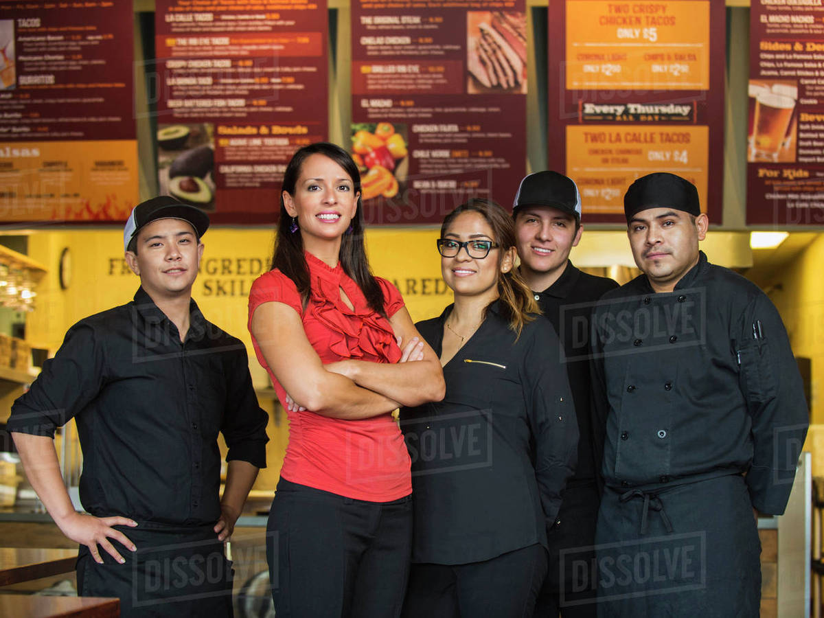 Hispanic business owner and employees smiling in cafe - Royalty-free ...