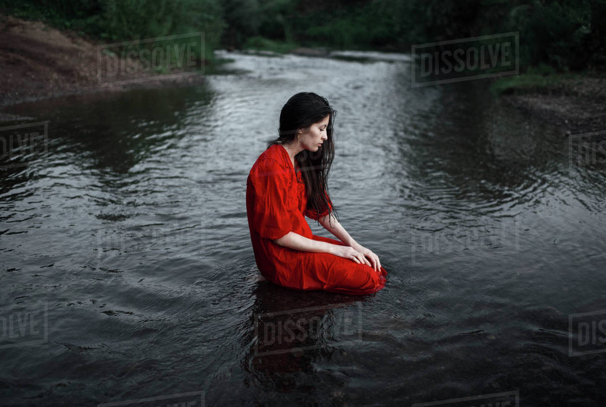 Caucasian woman sitting in remote stream - Royalty-free Stock Photo ...
