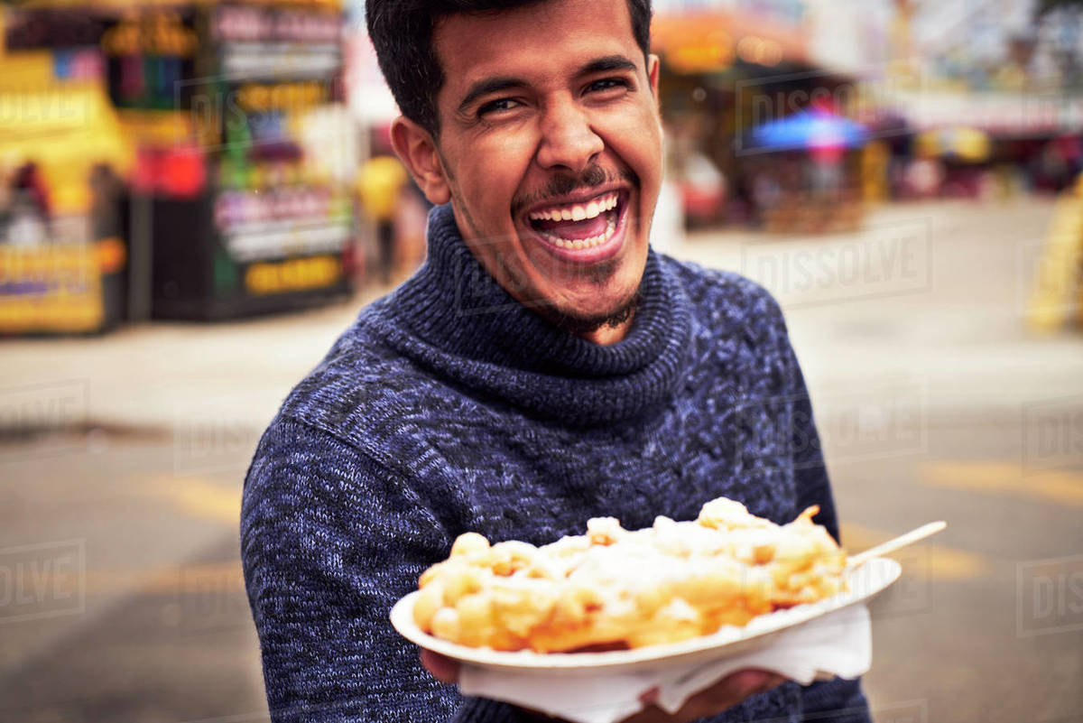 Laughing man showing plate of food at amusement park - Royalty-free ...