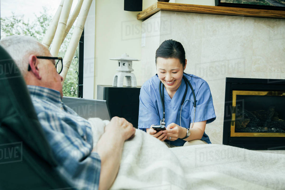 Nurse texting on cell phone near patient - Royalty-free Stock Photo ...