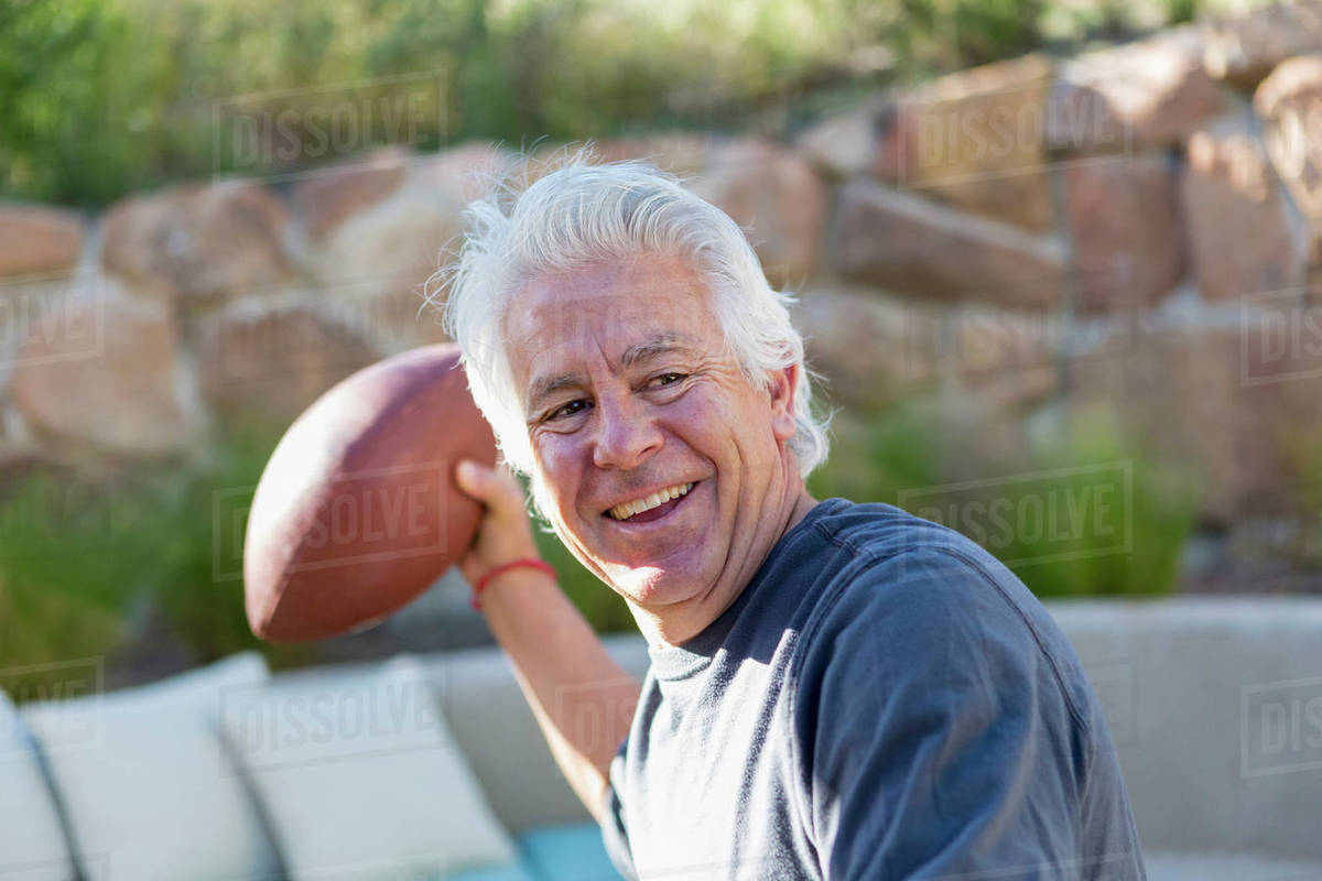 Caucasian man throwing football - Royalty-free Stock Photo | Dissolve