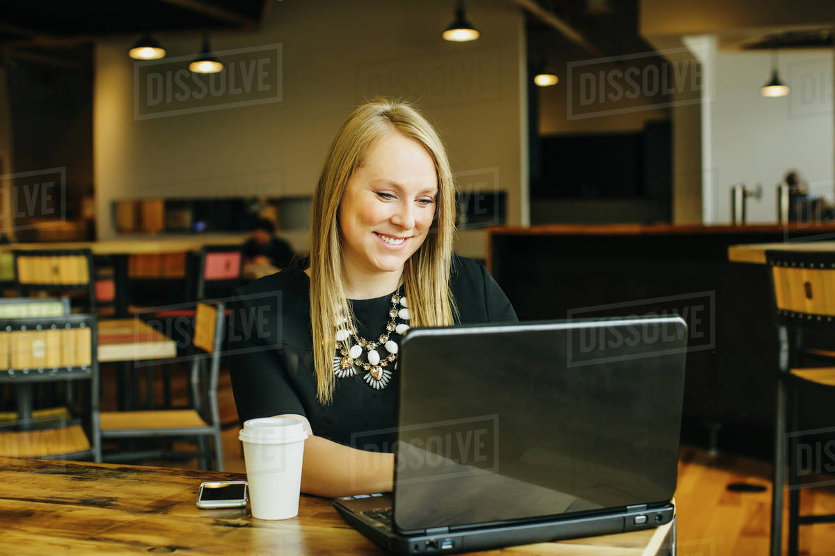 Caucasian businesswoman working on laptop in cafe - Royalty-free Stock ...