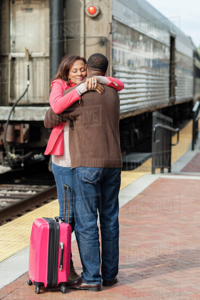 Couple hugging at train station - Royalty-free Stock Photo | Dissolve