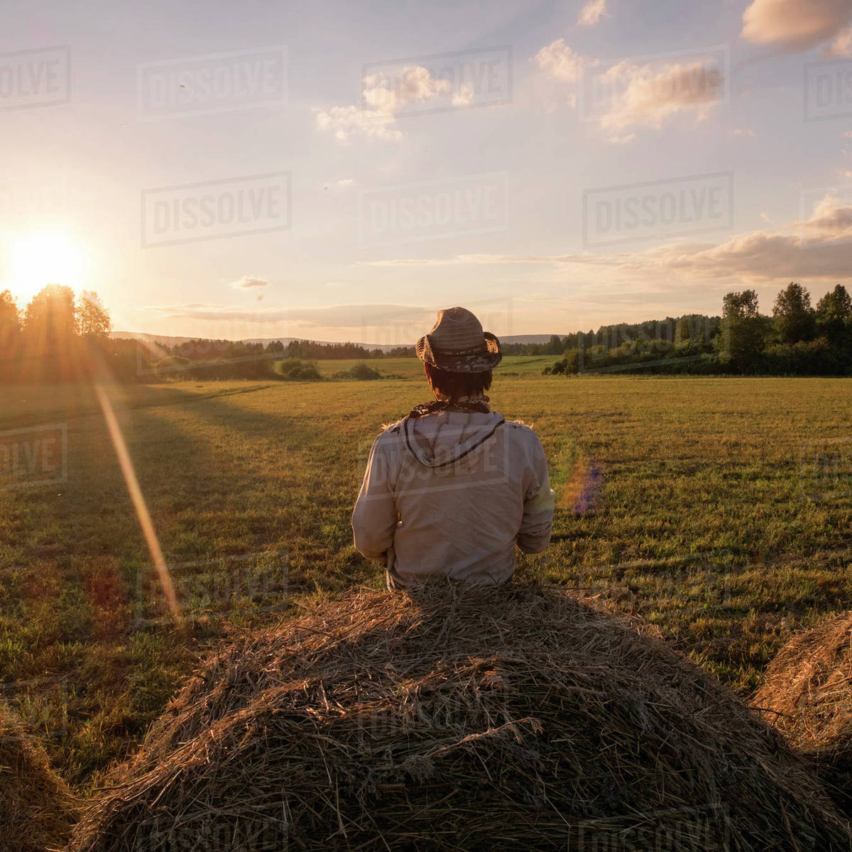 Mari man sitting on hay bale at sunset - Royalty-free Stock Photo ...