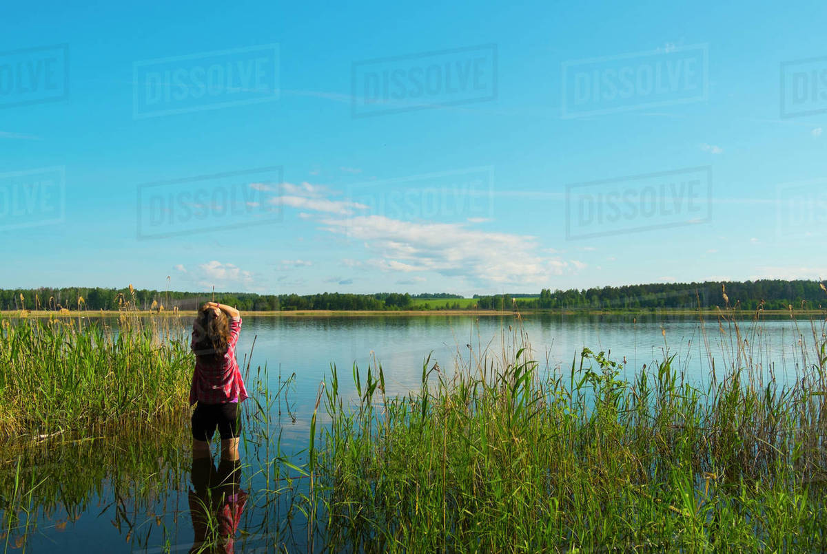 Caucasian woman wading in river - Royalty-free Stock Photo | Dissolve