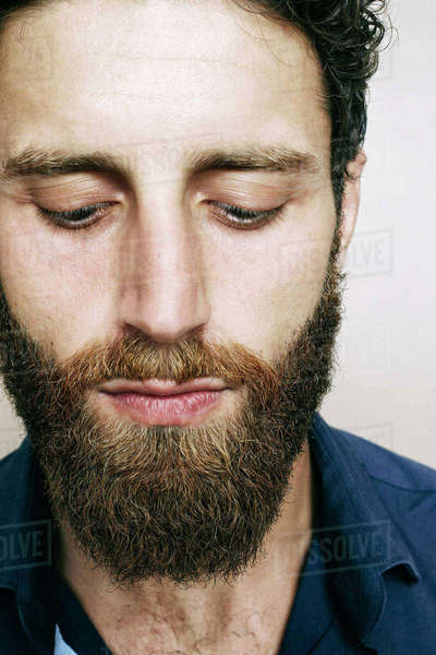 Caucasian man with beard looking down - Royalty-free Stock Photo | Dissolve