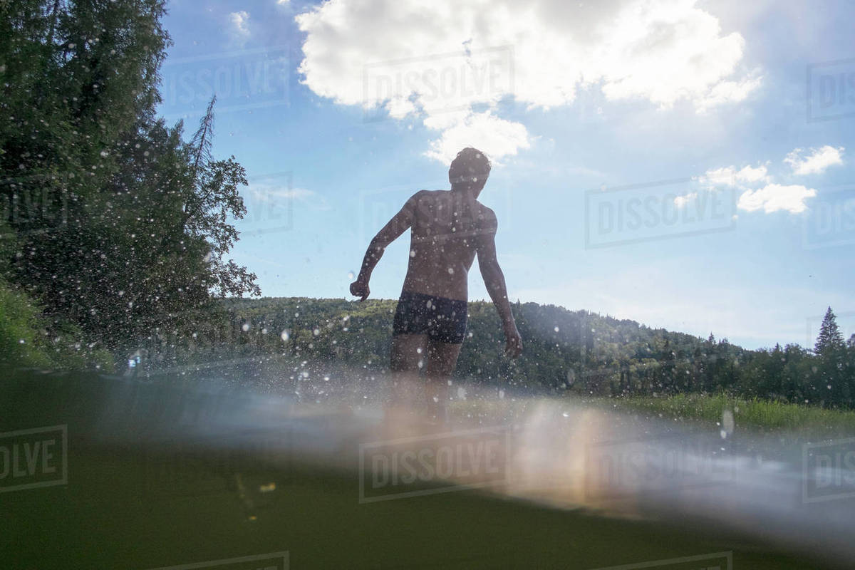 Mari man wading in lake - Stock Photo - Dissolve