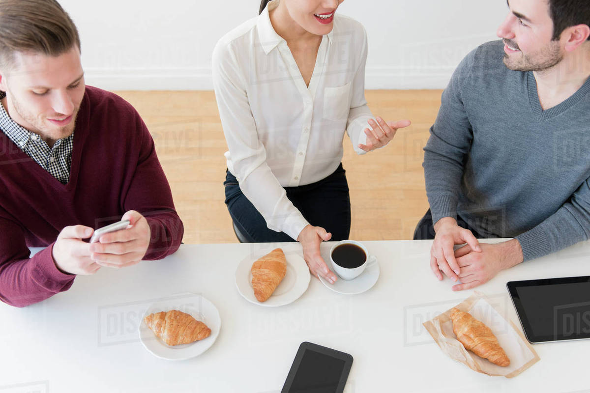 Business people eating croissants at table - Royalty-free Stock Photo ...