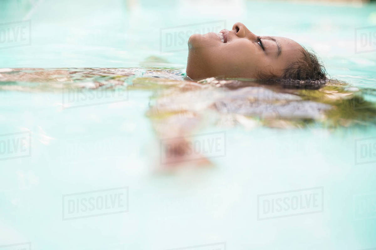 Surface level view of Hispanic girl floating in swimming pool - Stock ...