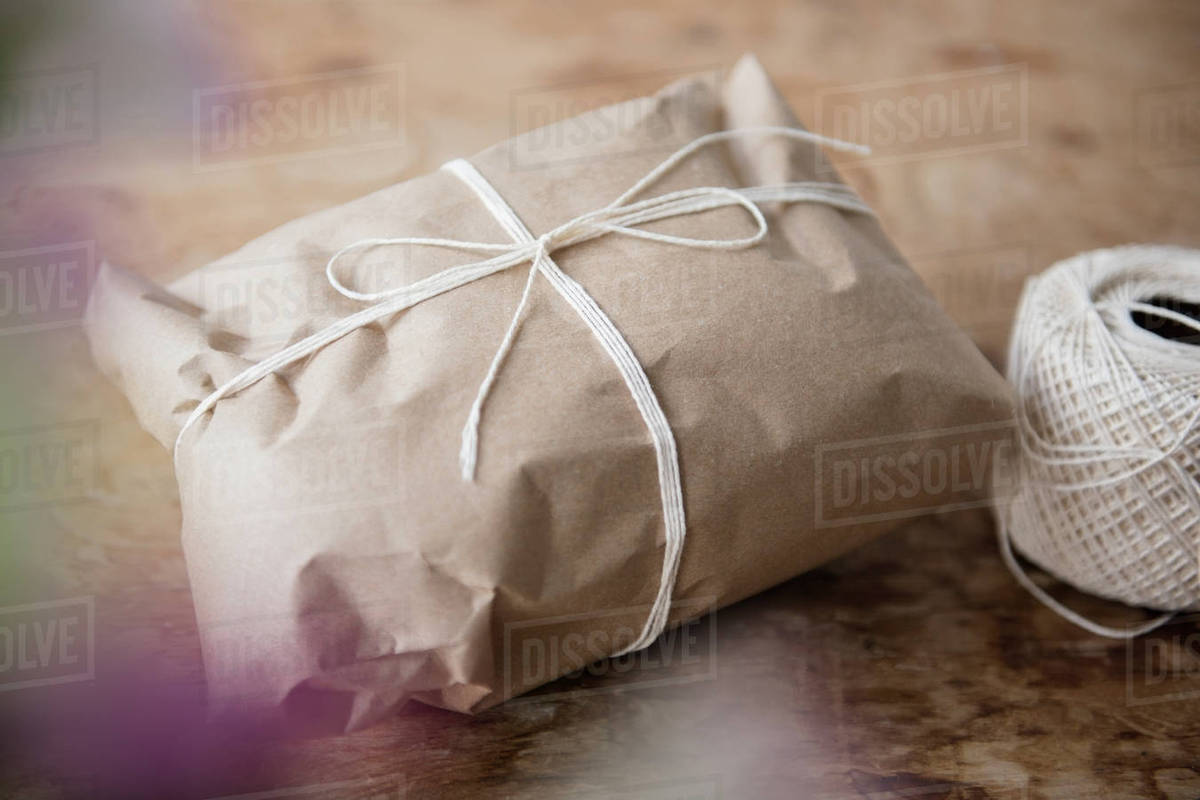 String tied around package wrapped in brown paper - Stock Photo - Dissolve