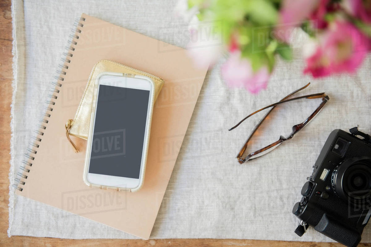 Camera, cell phone, purse, notebook and wallet on table - Royalty-free ...