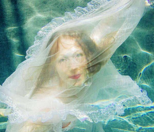 Caucasian woman wearing dress swimming underwater - Royalty-free Stock ...