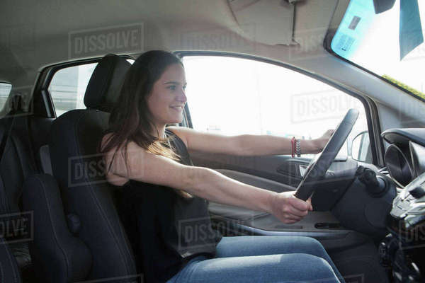 Smiling Hispanic woman driving car - Royalty-free Stock Photo | Dissolve